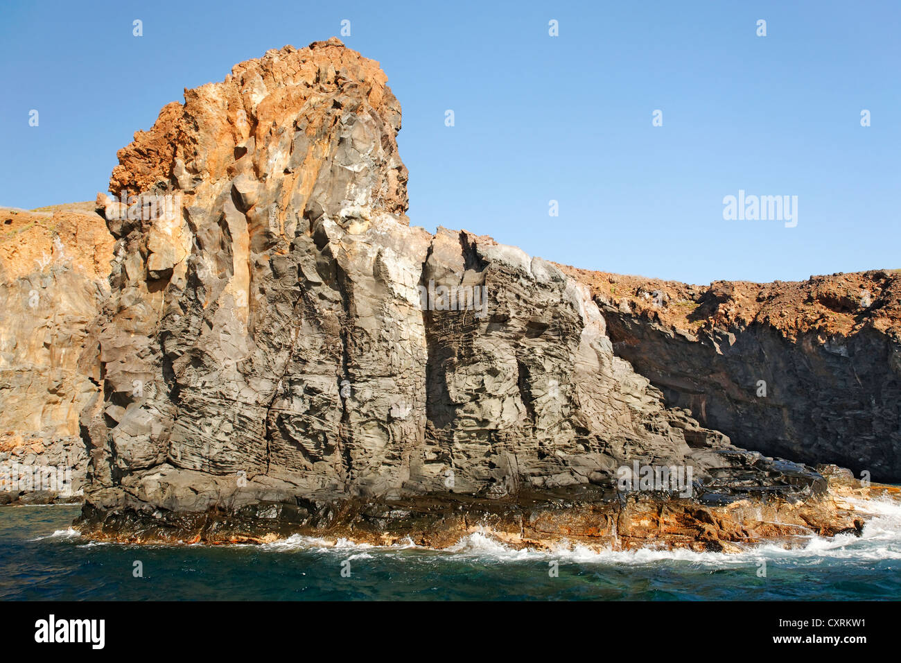 Steep volcanic cliffs, rock layers on the coast, San Benedicto Island ...