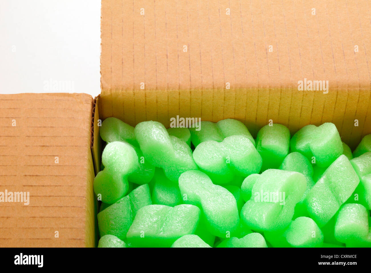 A cardboard box with green packing styrofoam peanuts Stock Photo - Alamy