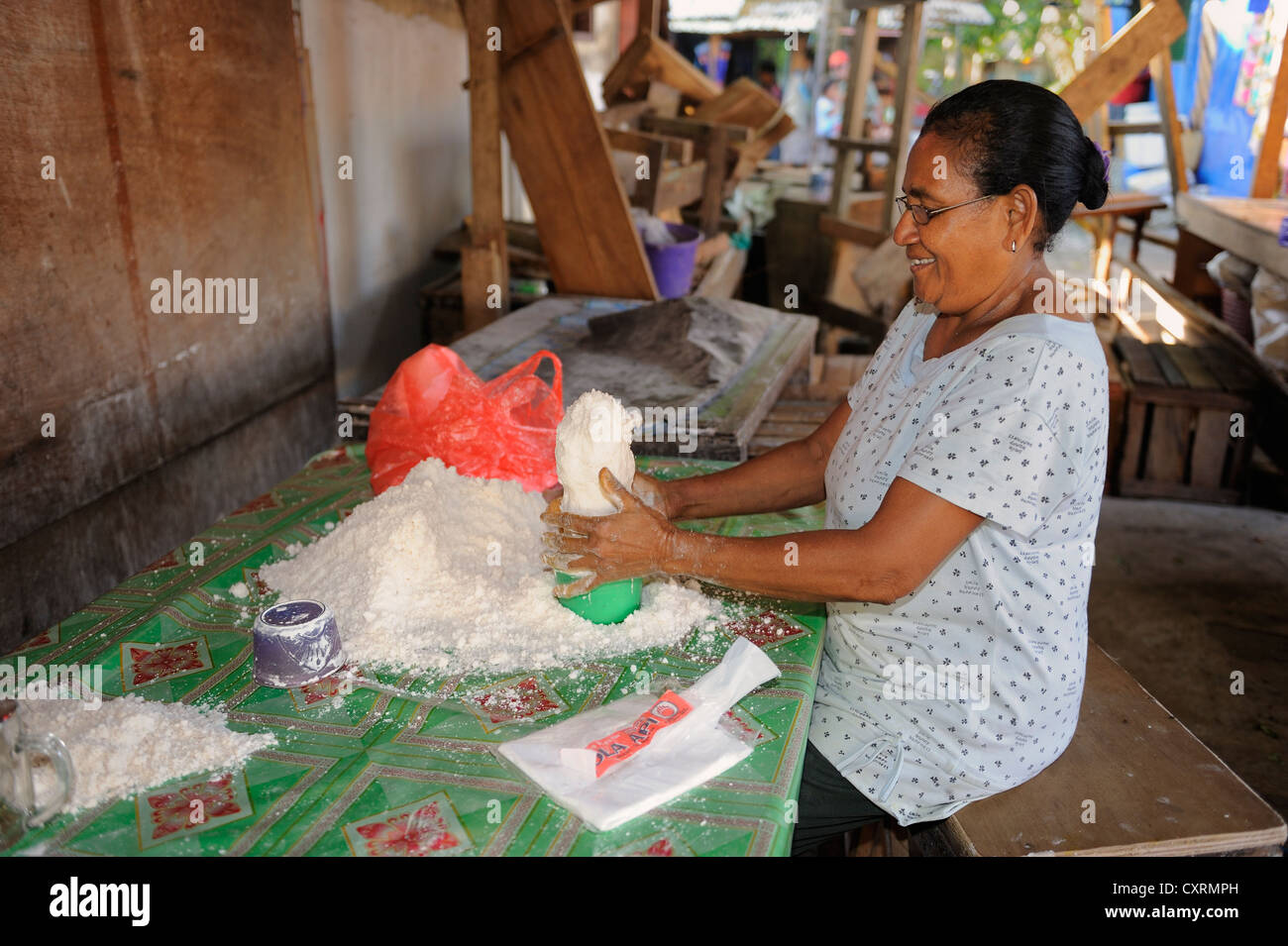 Sago being pressed into a form by a Papuan woman and offered for sale ...