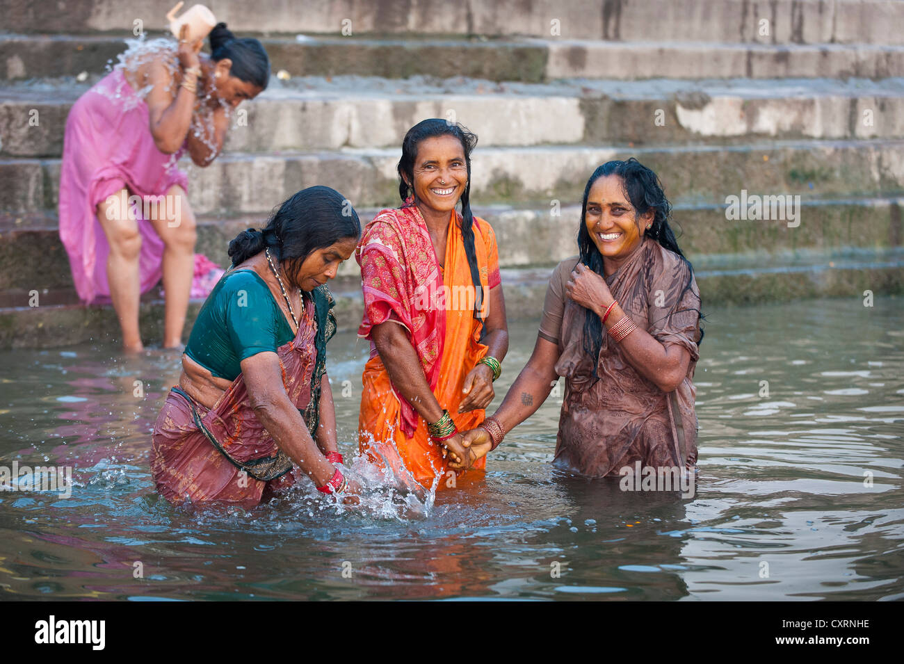 Smiling women taking a bath in the Ganges, Ghats, Varanasi, Benares ...