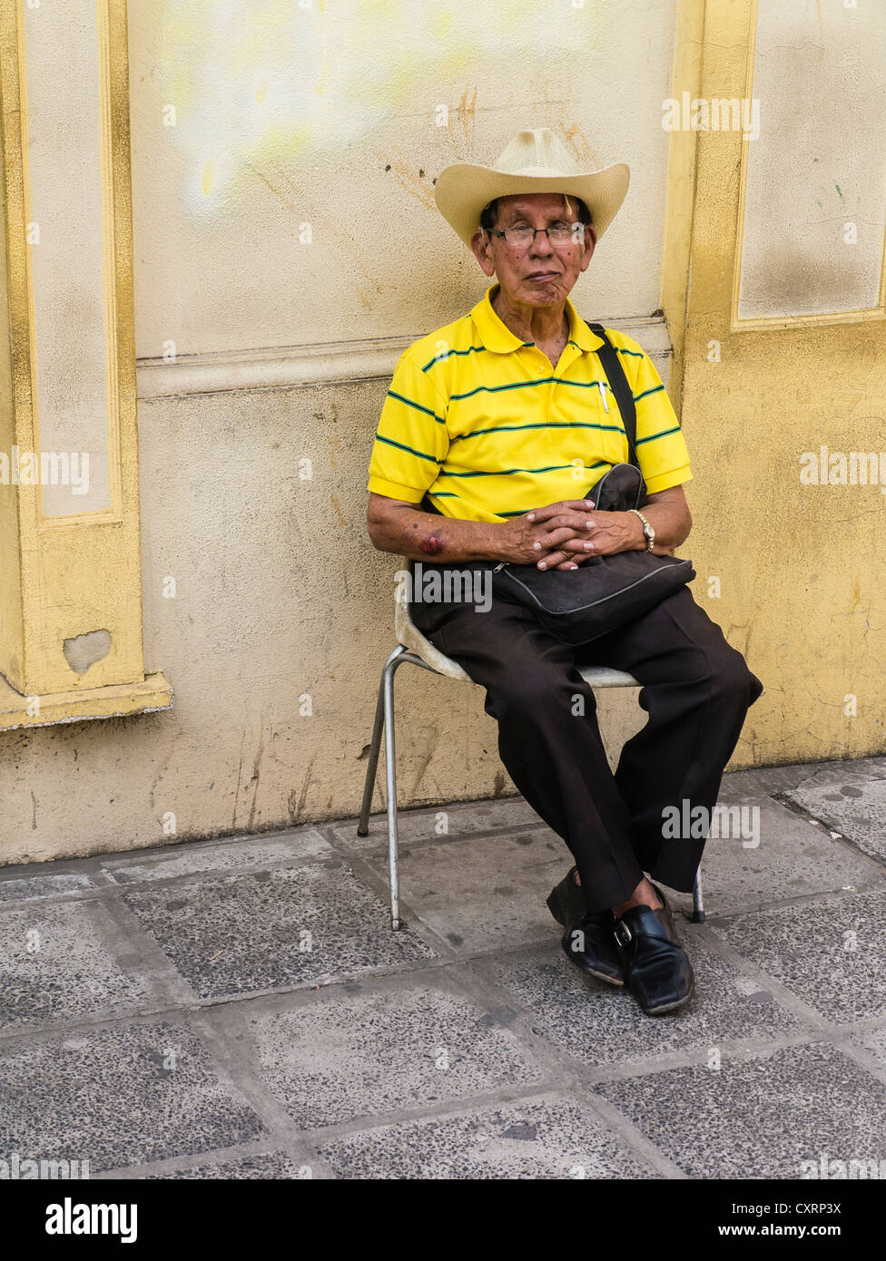 A Paraguayan male senior citizen sitting on a chair and leaning against ...