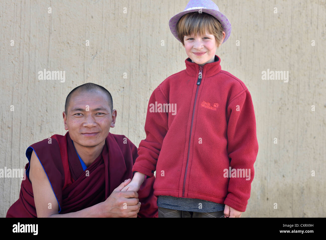 Monk holding the hand of a European child, 6 years, Labrang Monastery ...