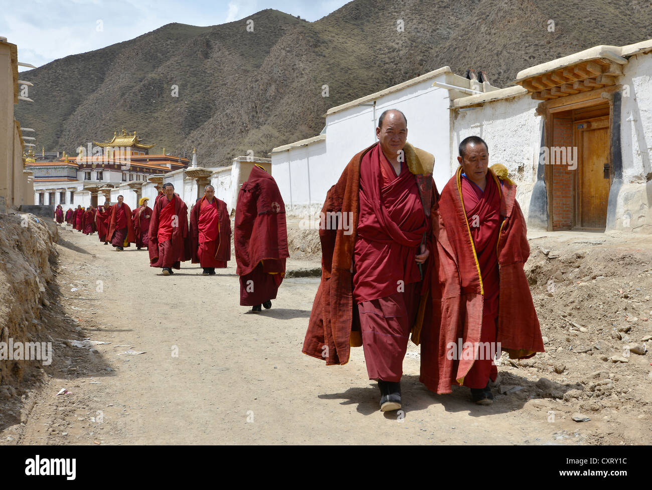Tibetan Buddhism, monks and novices walking along the buildings wearing ...