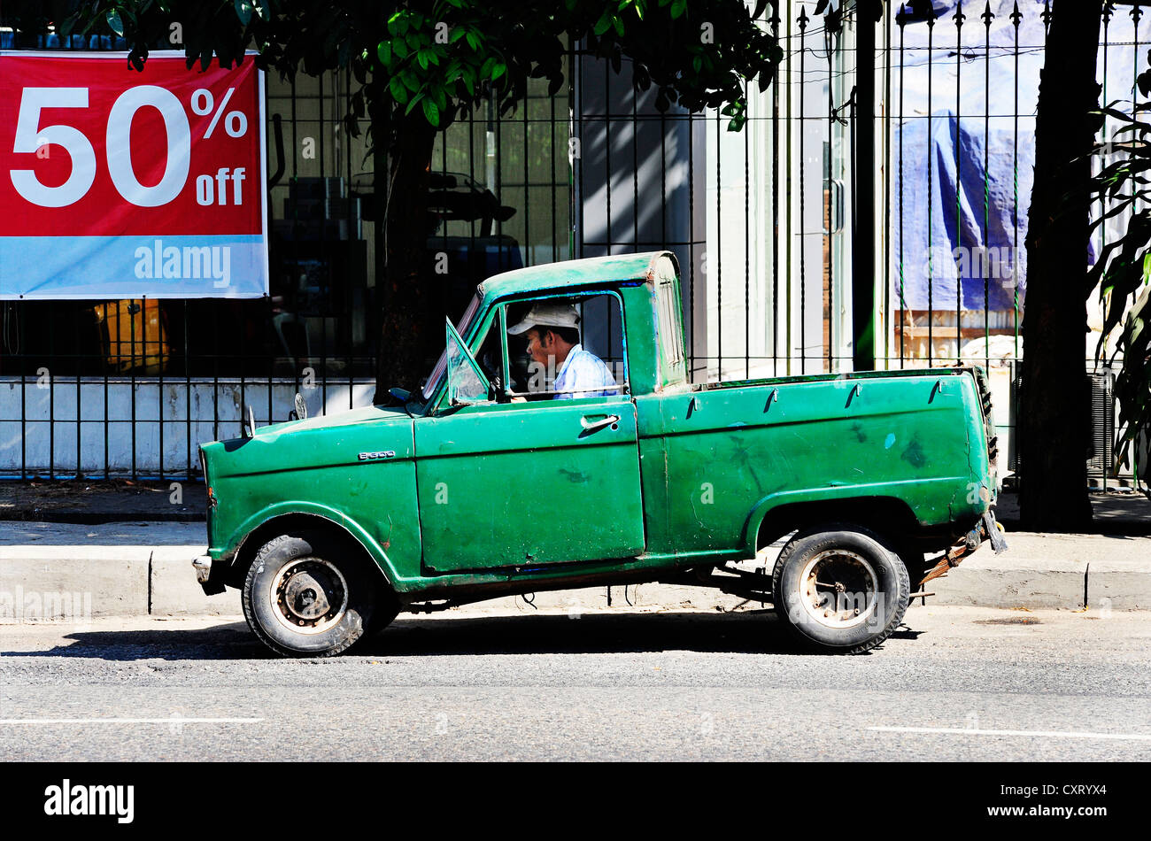 Small car and a sign, lettering 50% off, Yangon, Burma also known as ...