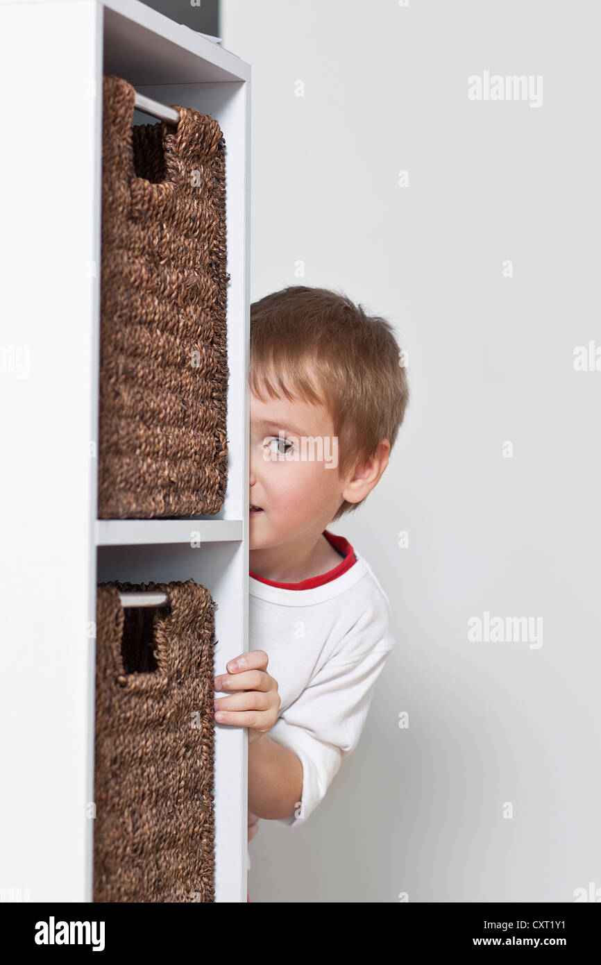 Boy hiding behind shelf hi-res stock photography and images - Alamy