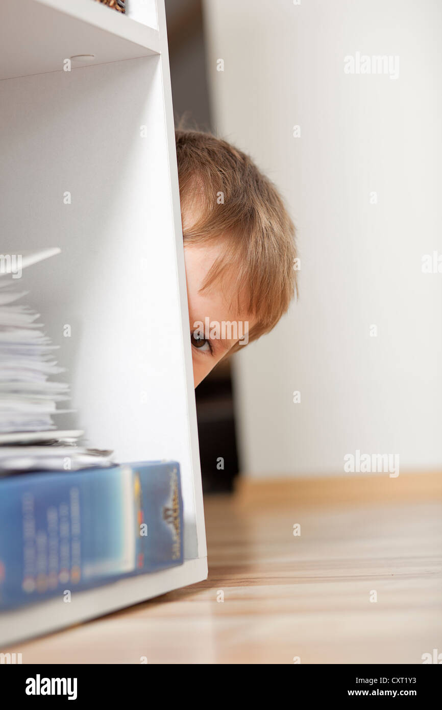 Boy hiding behind shelf hi-res stock photography and images - Alamy