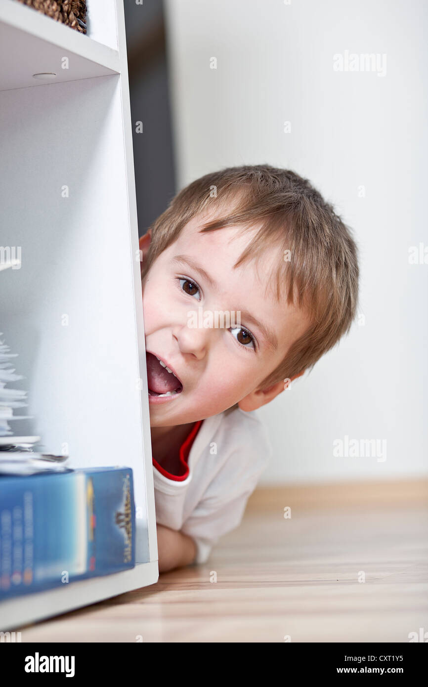 Boy hiding behind shelf hi-res stock photography and images - Alamy