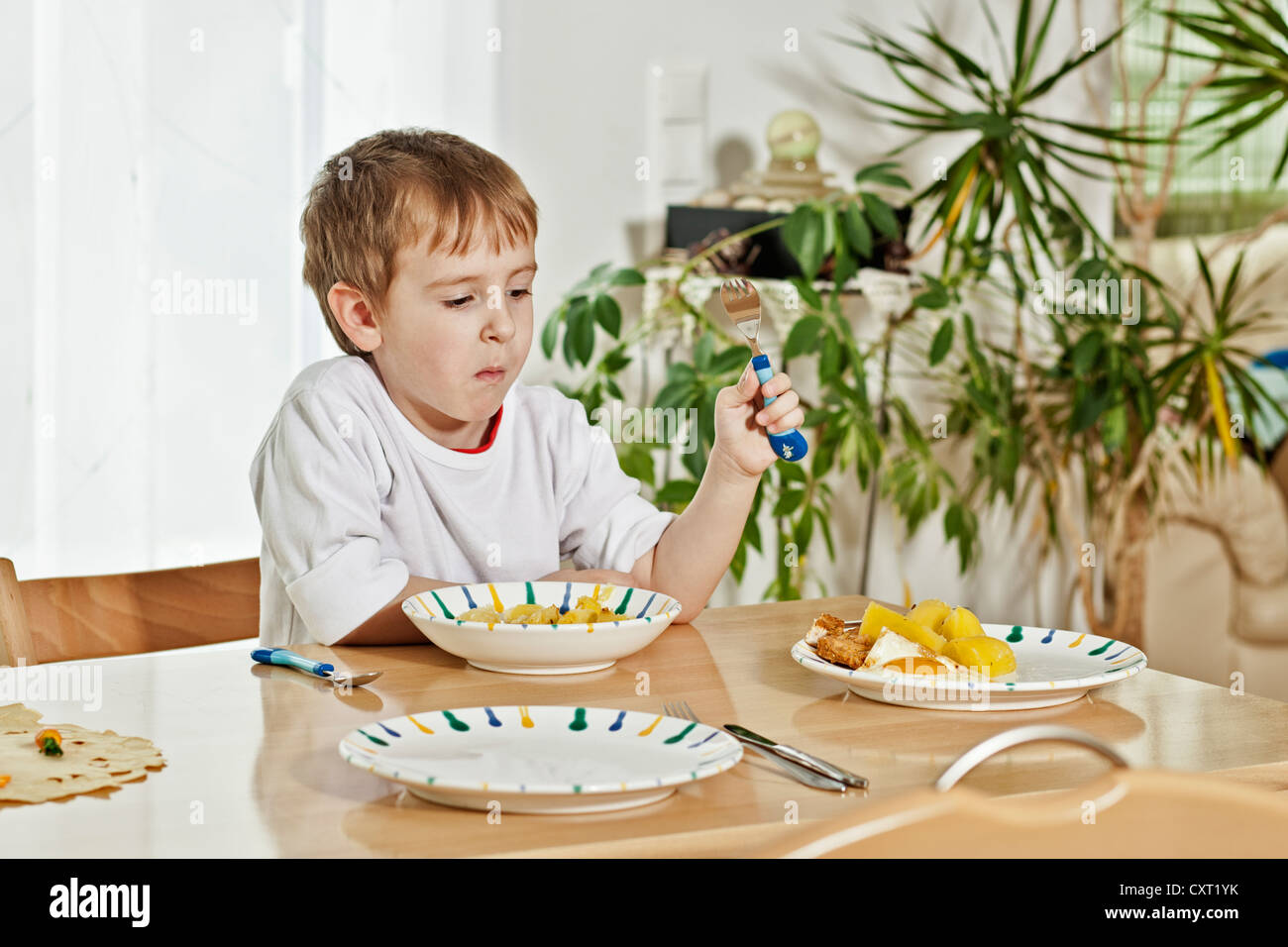 Boy sitting at the dinner table Stock Photo - Alamy