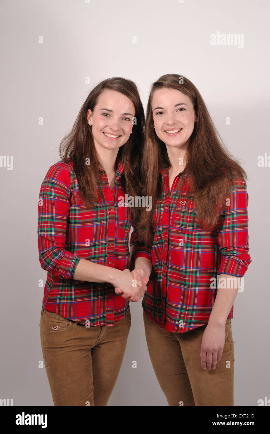 Twin sisters shaking hands Stock Photo - Alamy