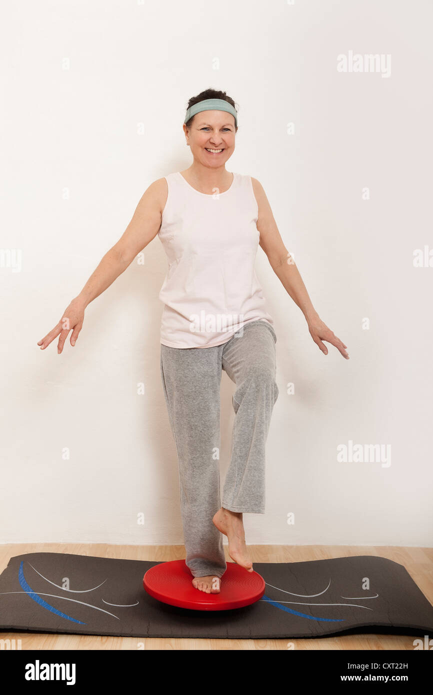 Woman standing on a balance ball Stock Photo - Alamy
