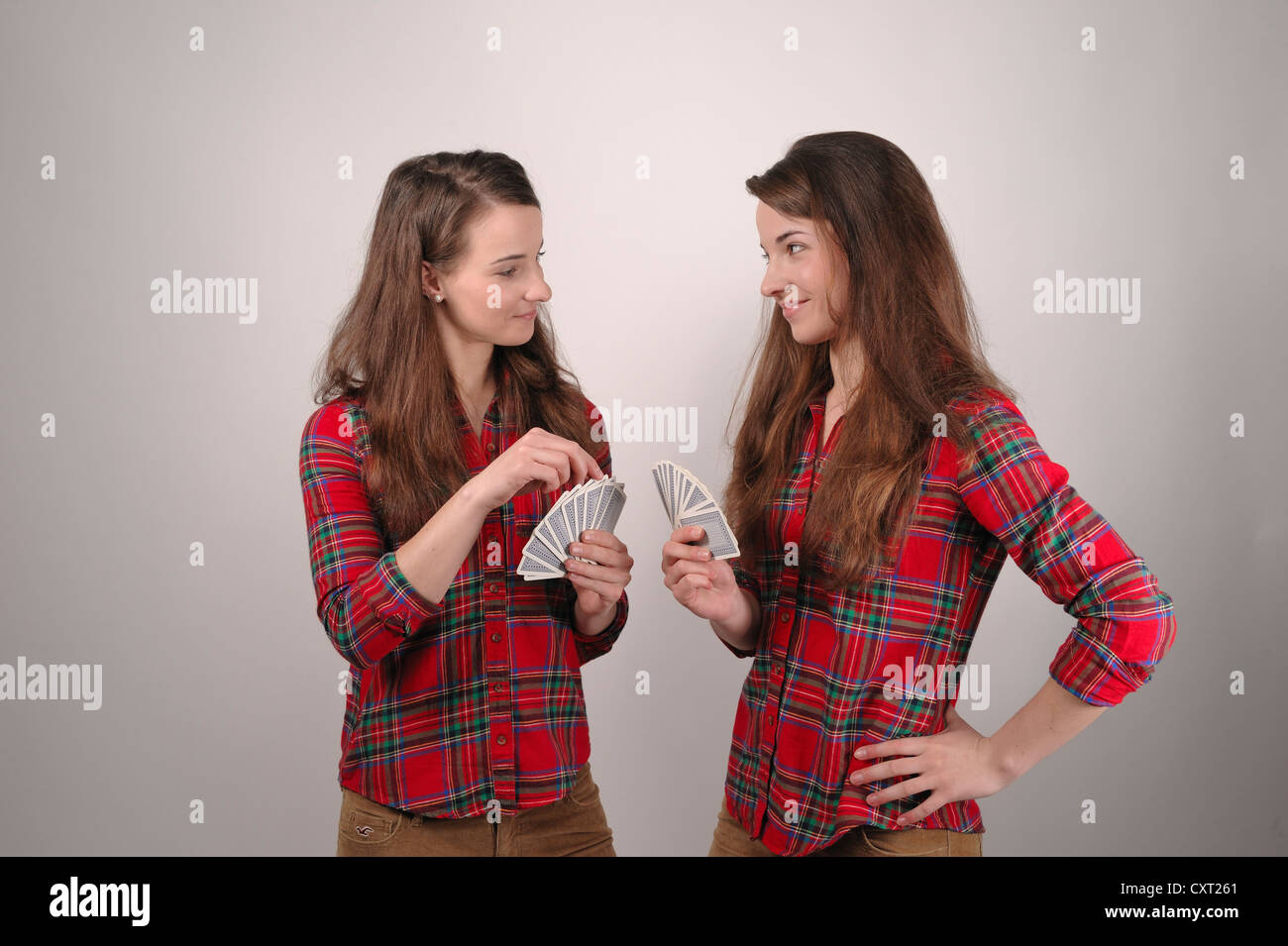 Twin sisters playing cards Stock Photo - Alamy