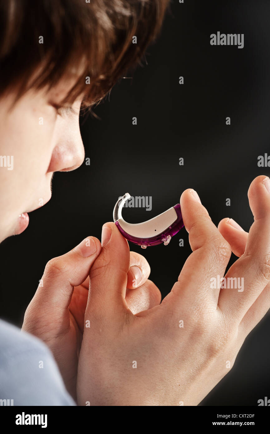 Boy looking at a hearing aid device Stock Photo - Alamy