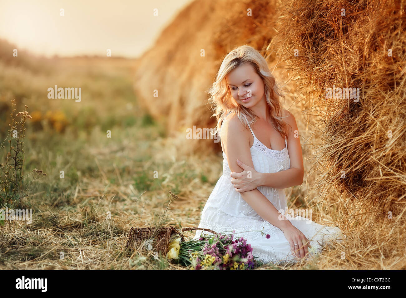 beautiful girl with blond hair posing near the haystack Stock Photo - Alamy