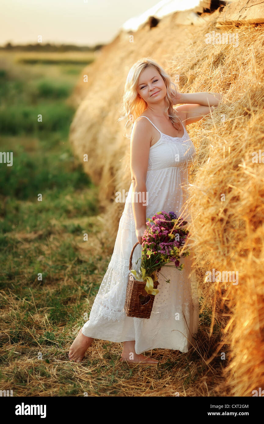 beautiful girl with blond hair posing near the haystack Stock Photo - Alamy