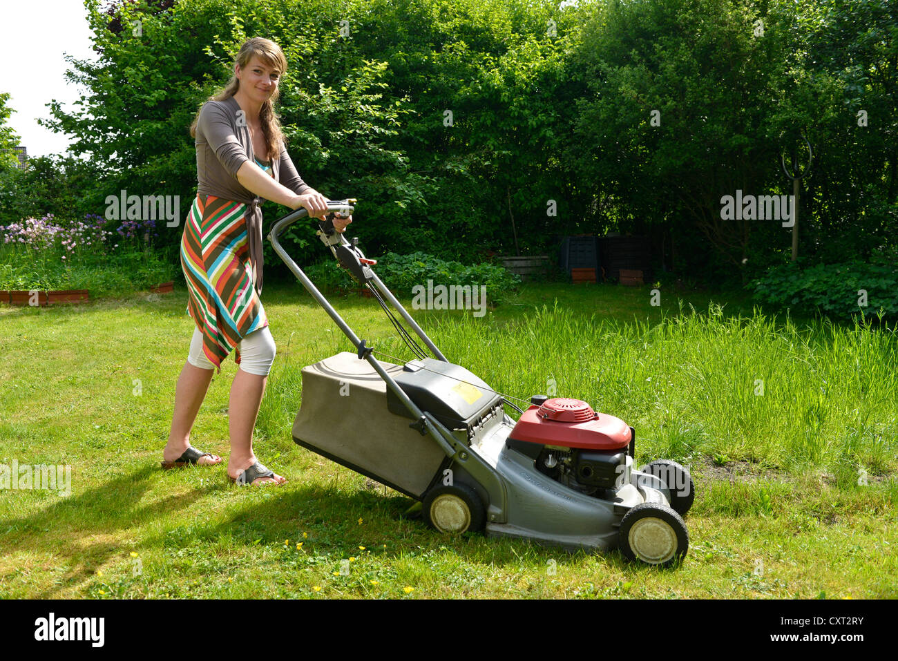 Woman pushing lawn mower hi-res stock photography and images - Alamy