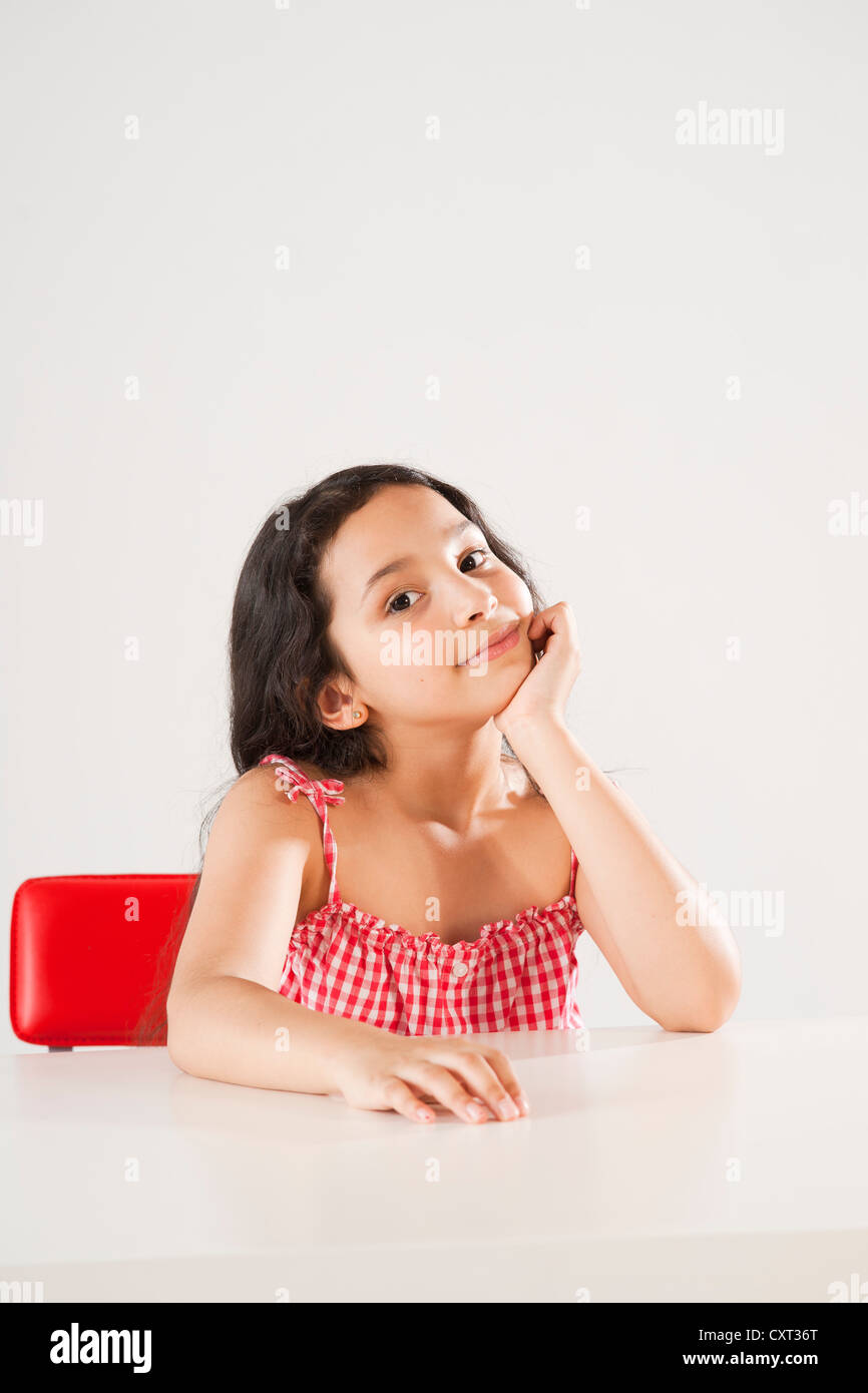 Girl sitting at a table Stock Photo - Alamy
