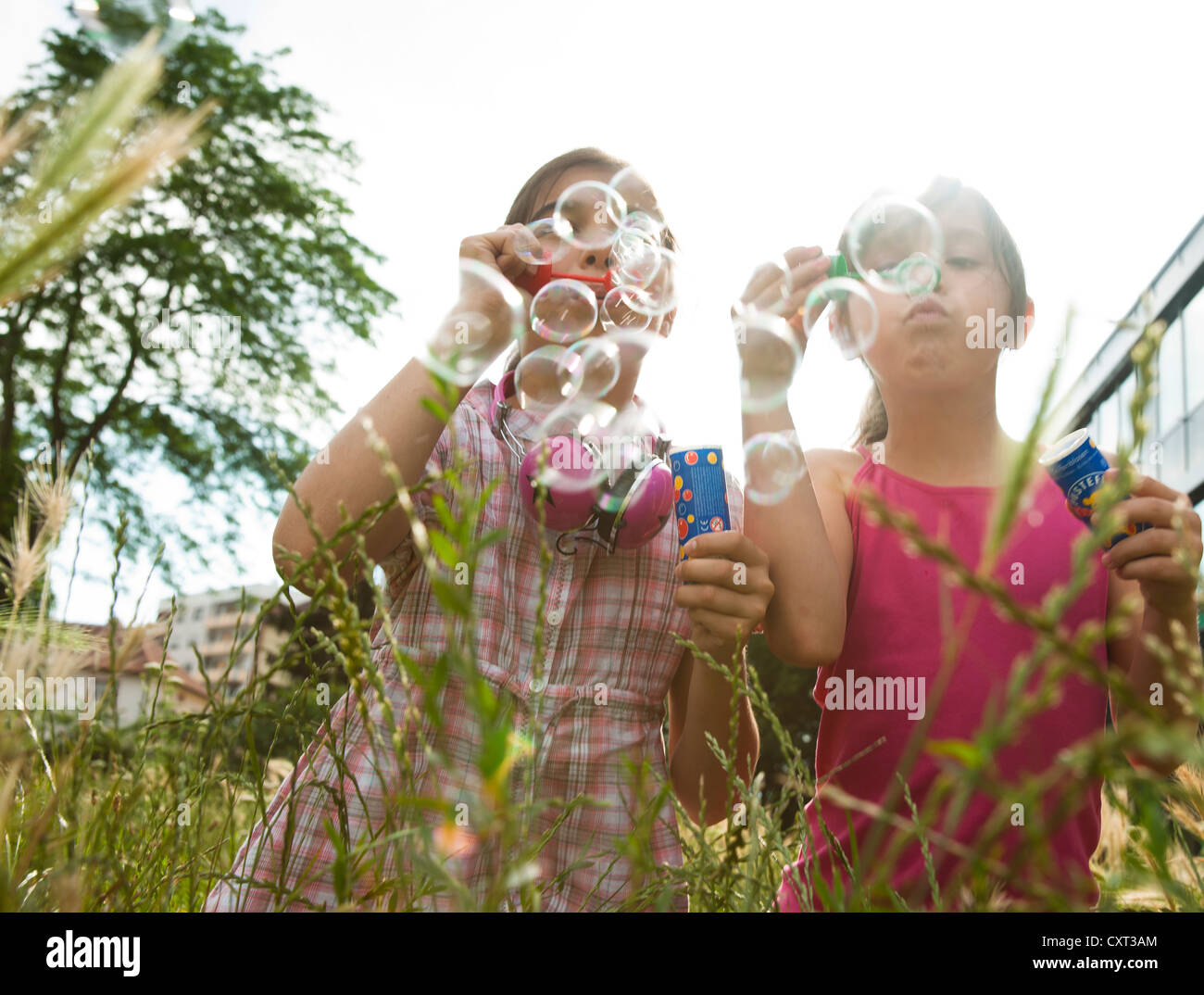 Two girls blowing soap bubbles Stock Photo - Alamy