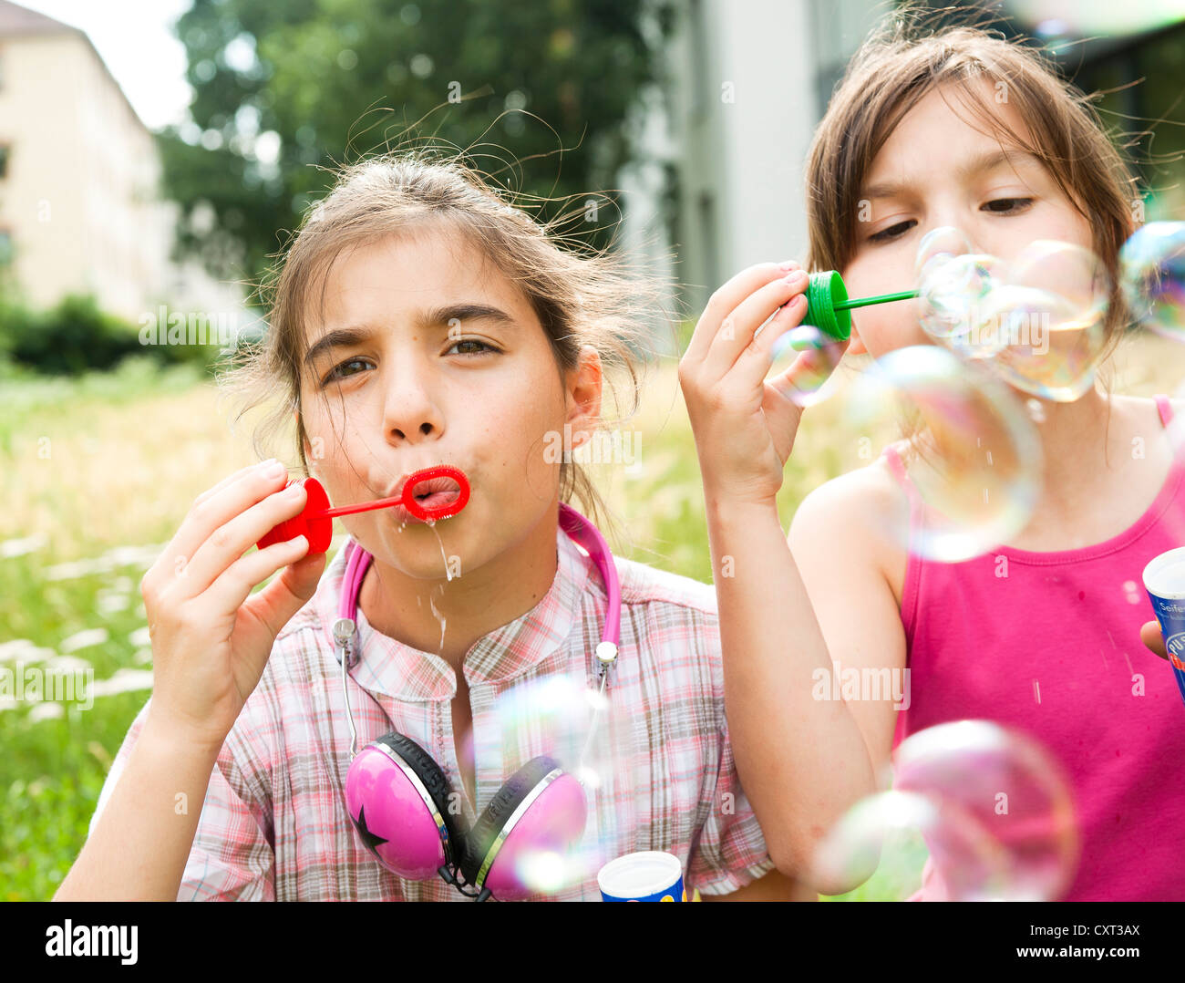 Two girls blowing soap bubbles Stock Photo - Alamy