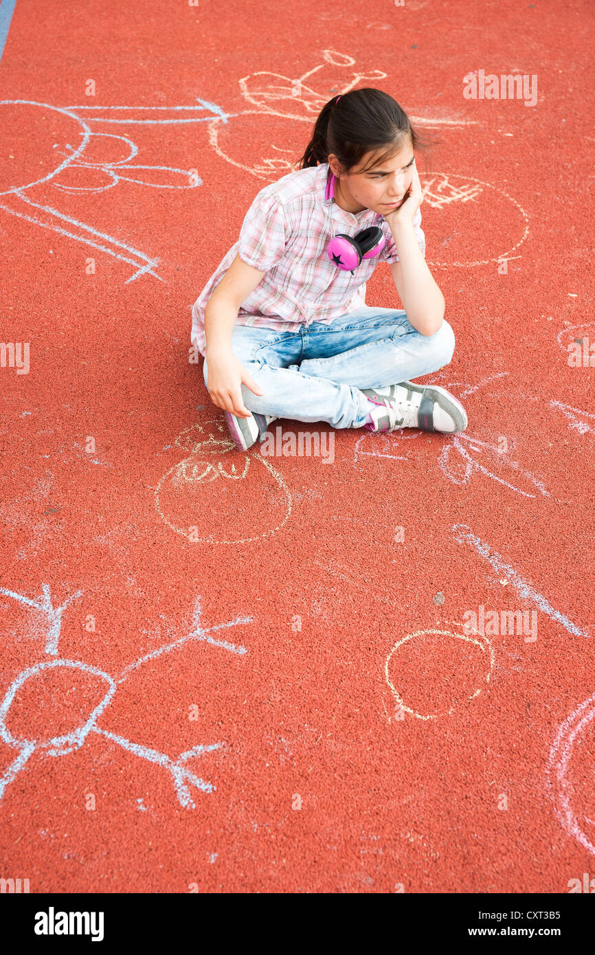 Girl sitting around bored on the school playground Stock Photo - Alamy