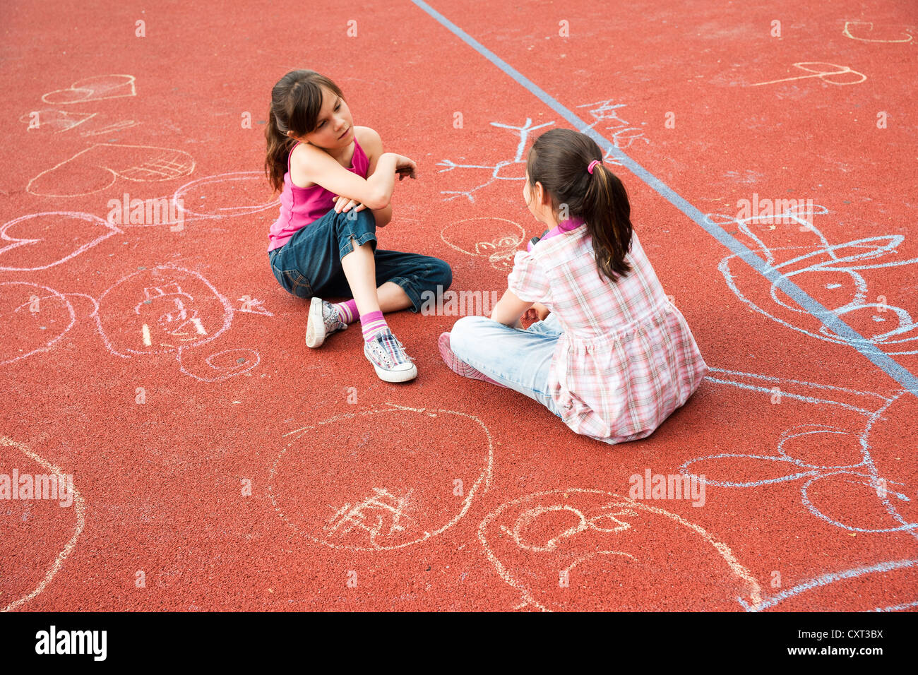 Two girls sitting around bored on the school playground Stock Photo - Alamy