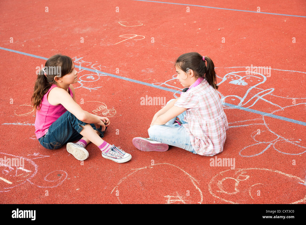 Two girls sitting around bored on the school playground Stock Photo - Alamy