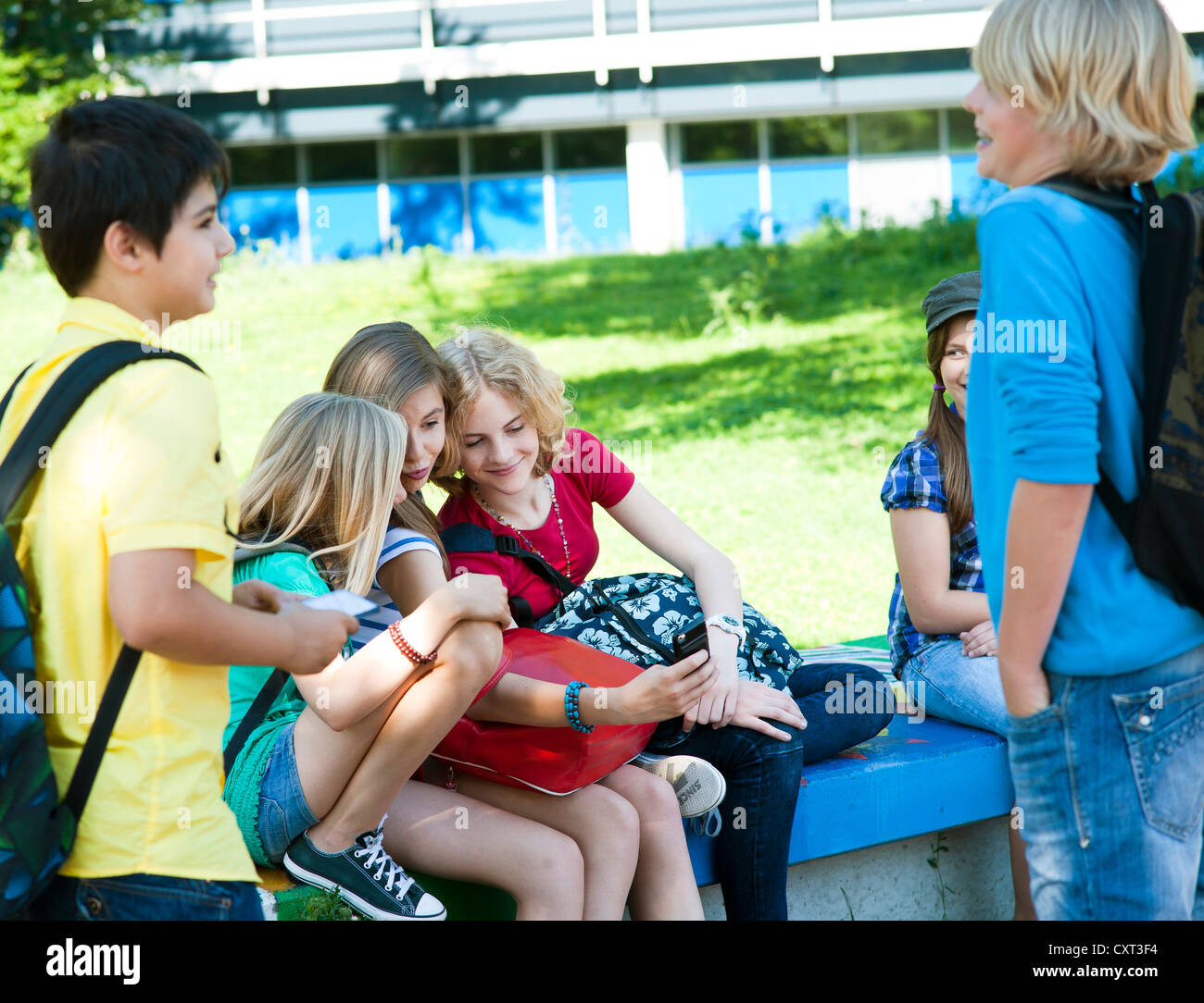 Group of schoolchildren sitting around in the school break and playing ...
