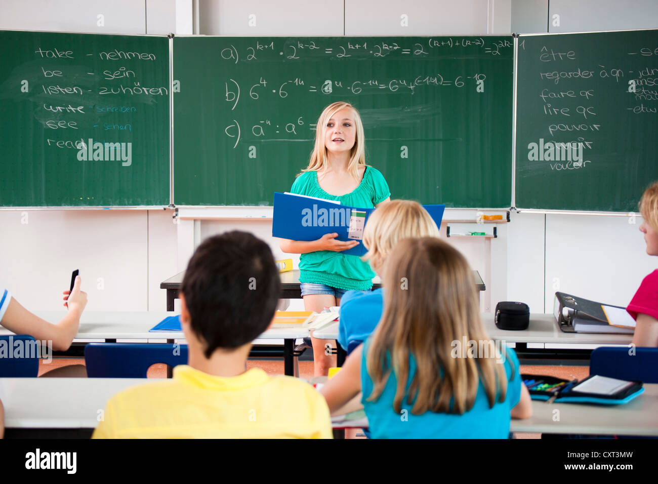 Schoolgirl standing in front of the class and making a presentation ...