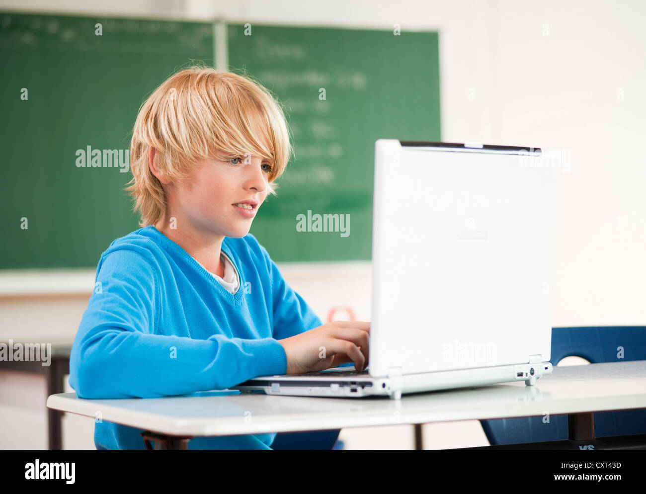 Schoolboy using a laptop in a classroom Stock Photo - Alamy