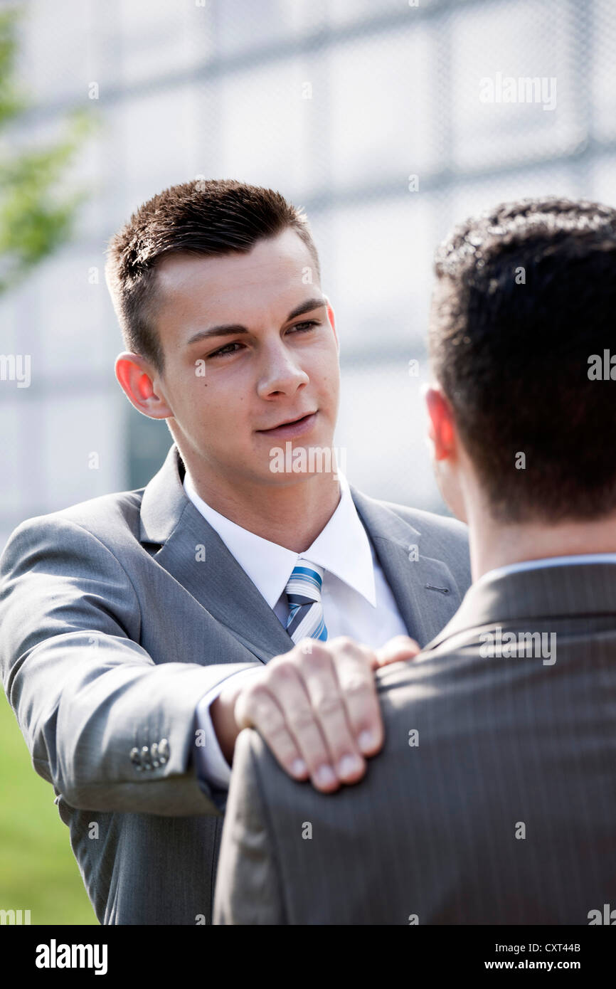 Young businessman talking to a colleague Stock Photo - Alamy