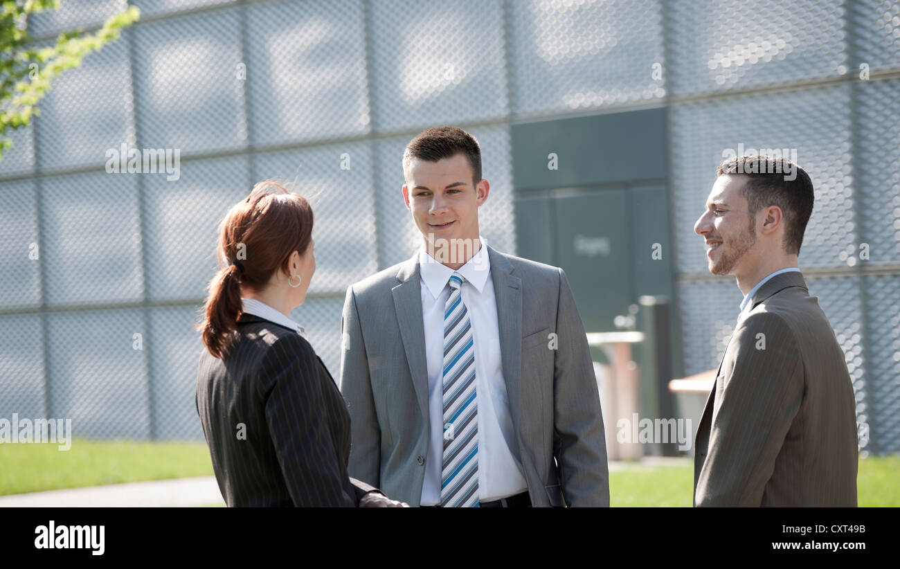 Business people talking in front of an office building Stock Photo - Alamy