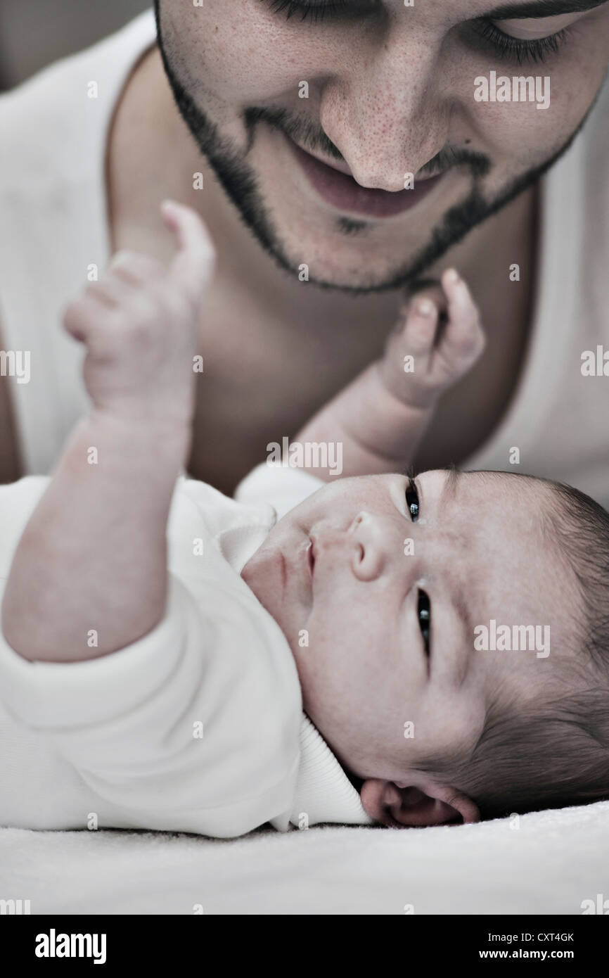 Father smiling lovingly at his newborn baby Stock Photo - Alamy