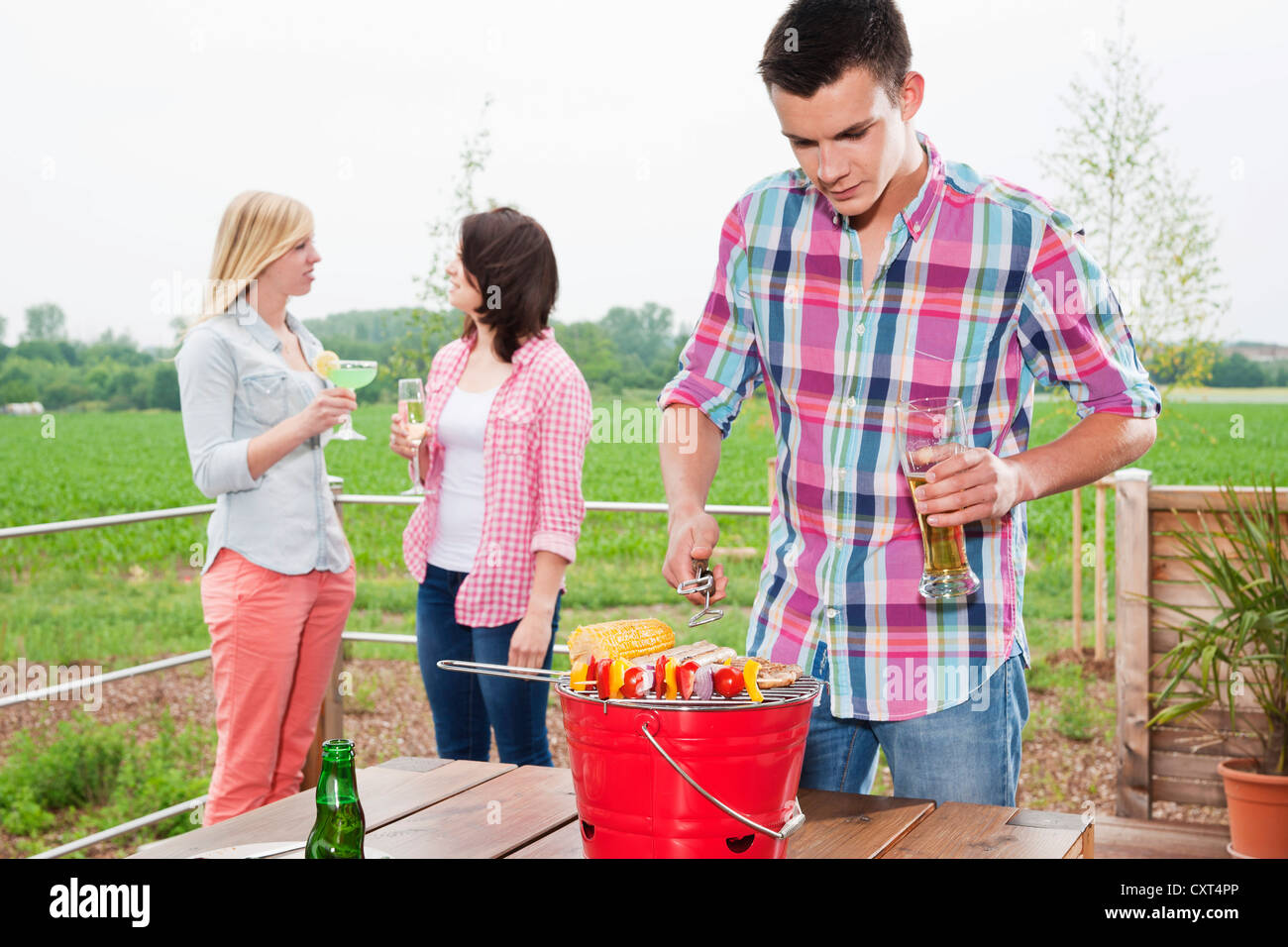 Young people having a barbecue on a terrace Stock Photo - Alamy