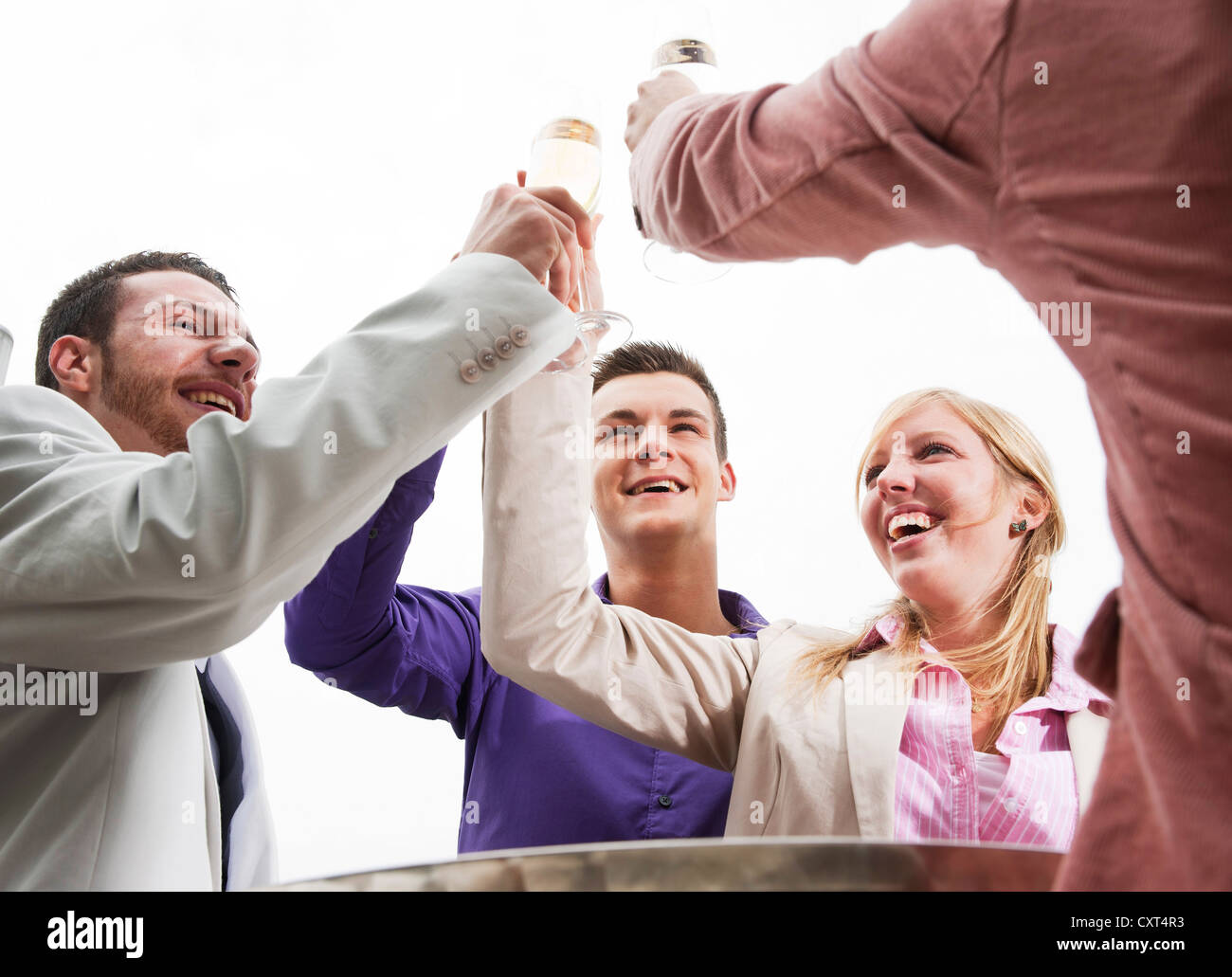 A group of young people chinking glasses, celebrating Stock Photo - Alamy