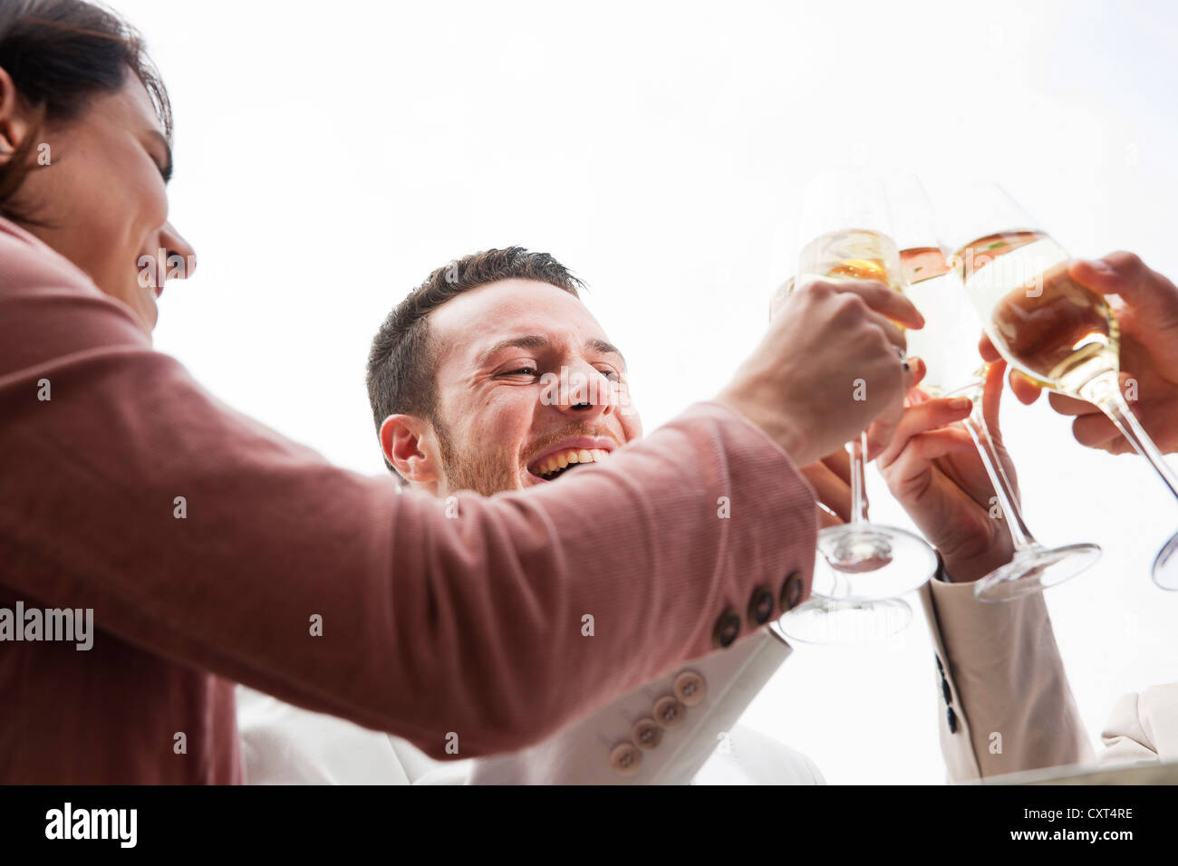 A group of young people chinking glasses, celebrating Stock Photo - Alamy
