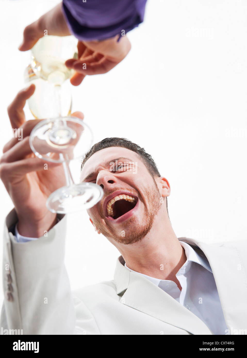 Happy young man, chinking glasses, celebrating on a terrace Stock Photo ...