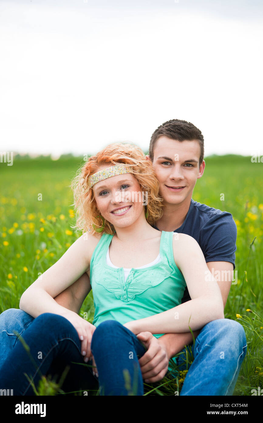 Smiling young couple sitting hi-res stock photography and images - Alamy