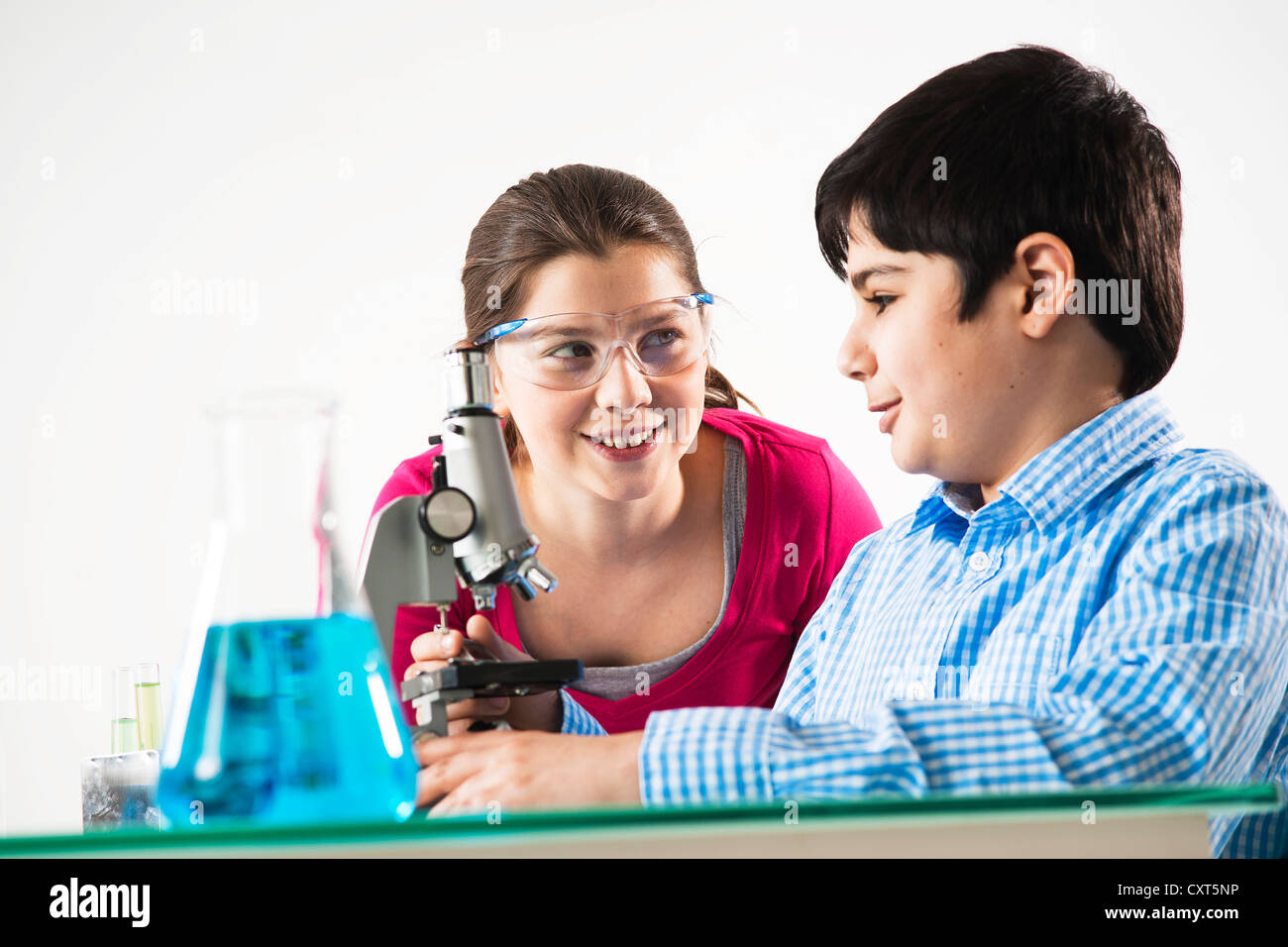 Boy and girl in front of a microscope Stock Photo - Alamy
