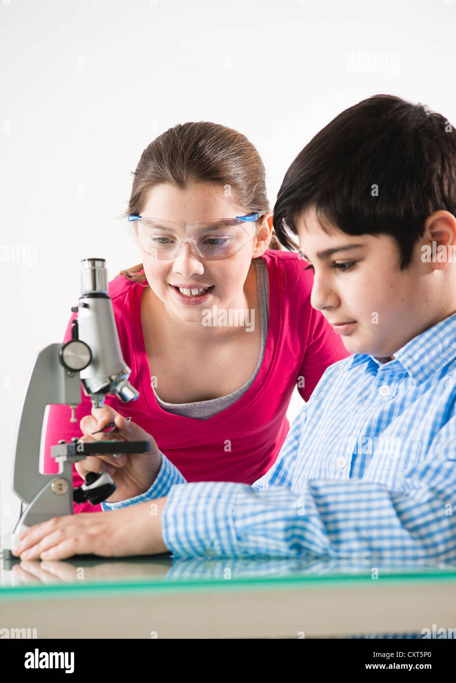 Boy and girl in front of a microscope Stock Photo - Alamy