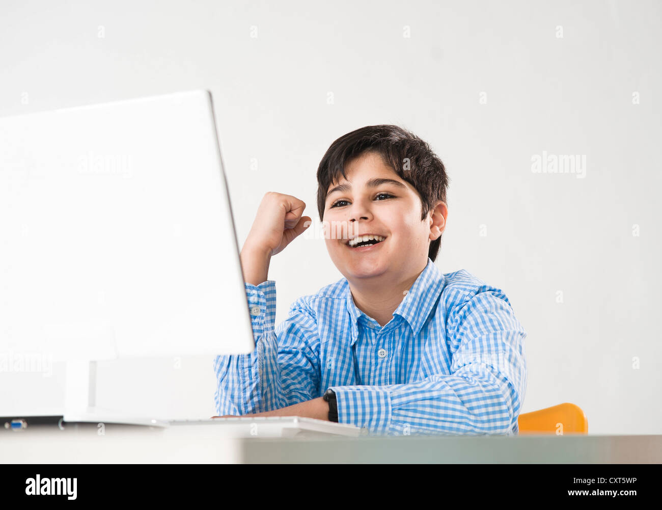 Boy in a cheerful mood is sitting at his computer Stock Photo - Alamy