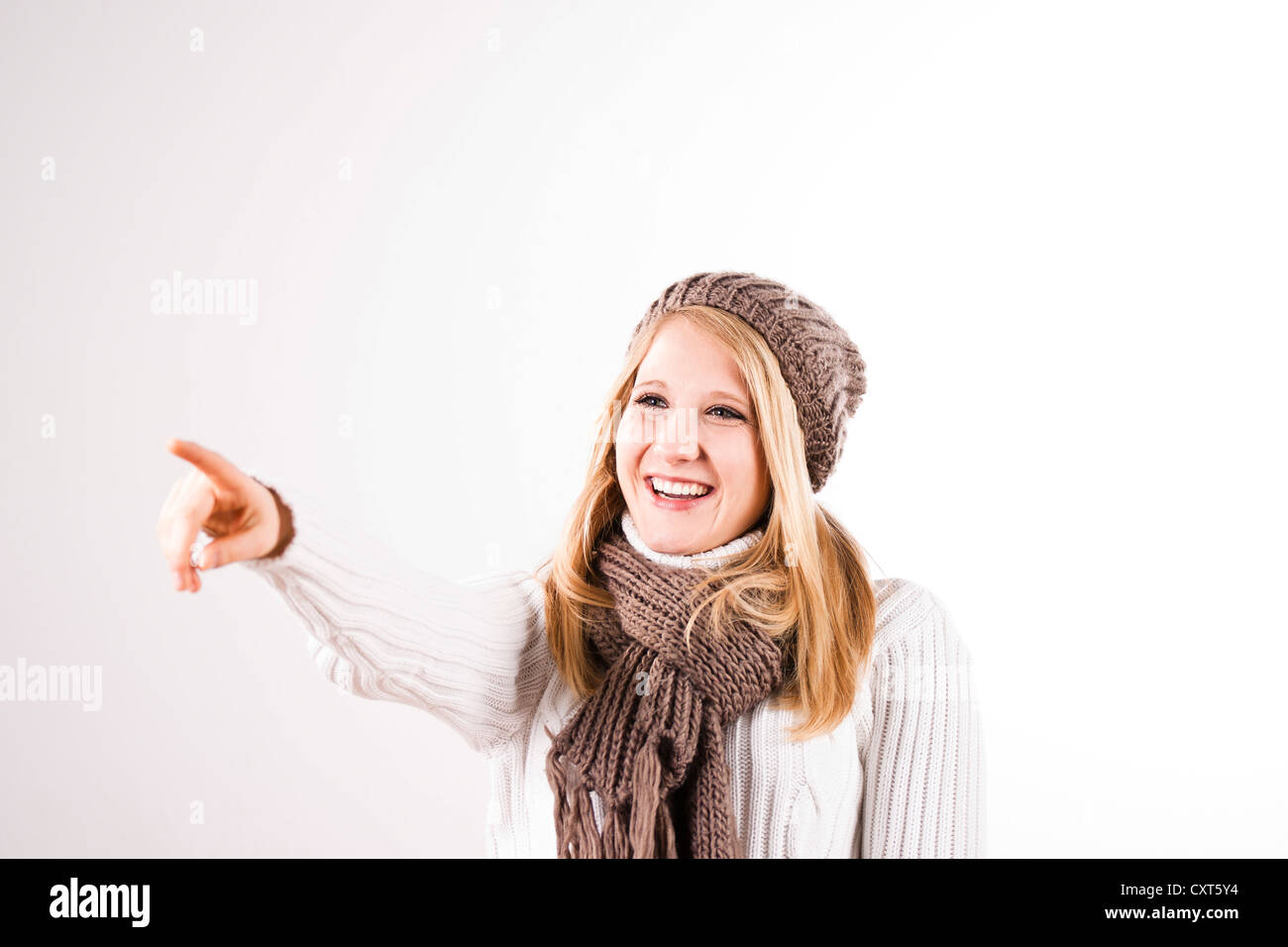 Young woman wearing a hat and scarf pointing into the distance Stock ...