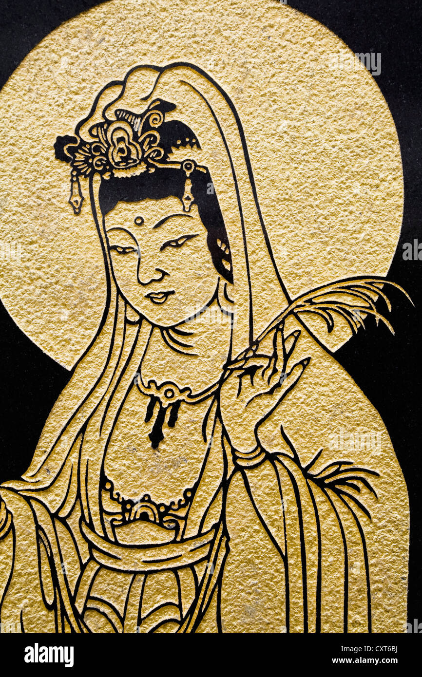 Chinese religious figure painted on a memorial monument in a cemetery ...