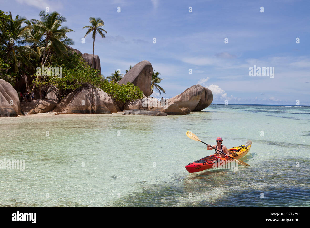 Woman, 40 years, kayaking in front of the Anse Source d'Argent rock ...
