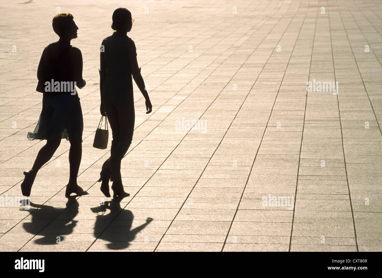 Two women walking over a square, silhouettes, Vilnius, Lithuania ...