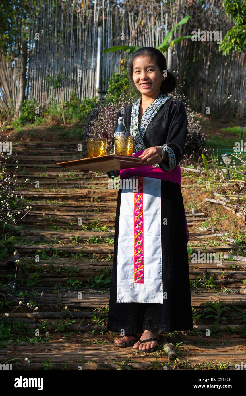 Traditionally dressed smiling waitress serving drinks, woman from the ...