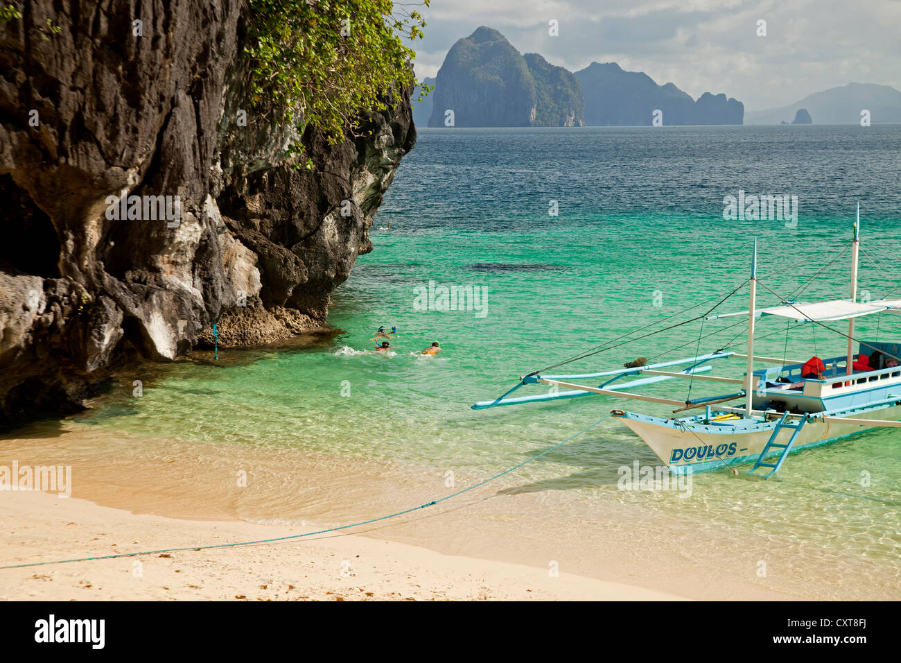 Snorkellers and a boat off Seven Commando Beach near El Nido, Palawan ...