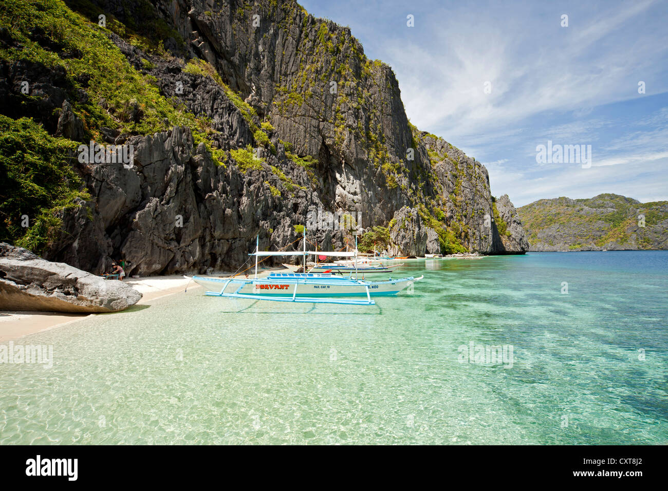 Outrigger boat off the steep limestone coast of Tapiutan Island, Bacuit ...