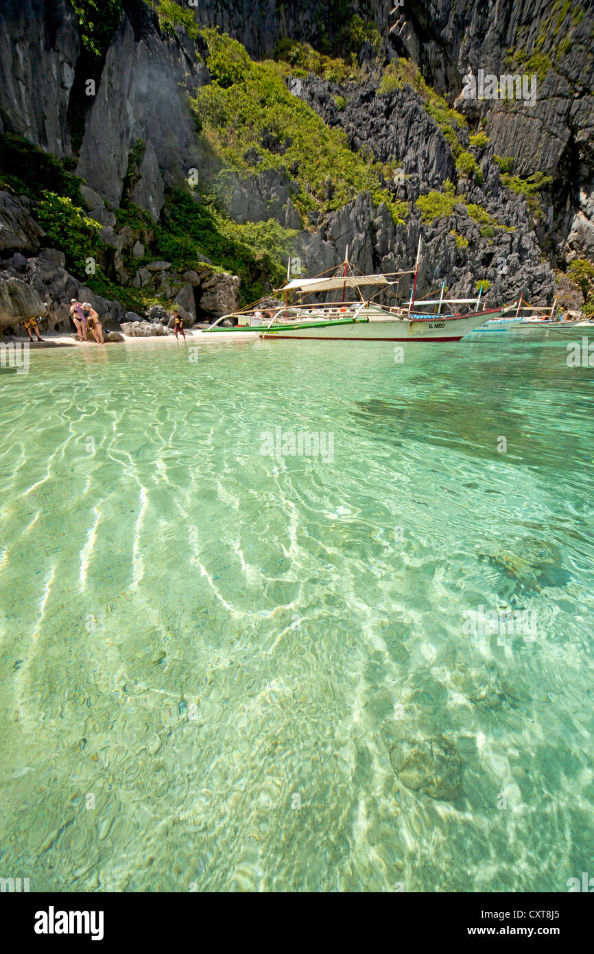 Bay on the steep limestone coast of Tapiutan Island, Bacuit archipelago ...