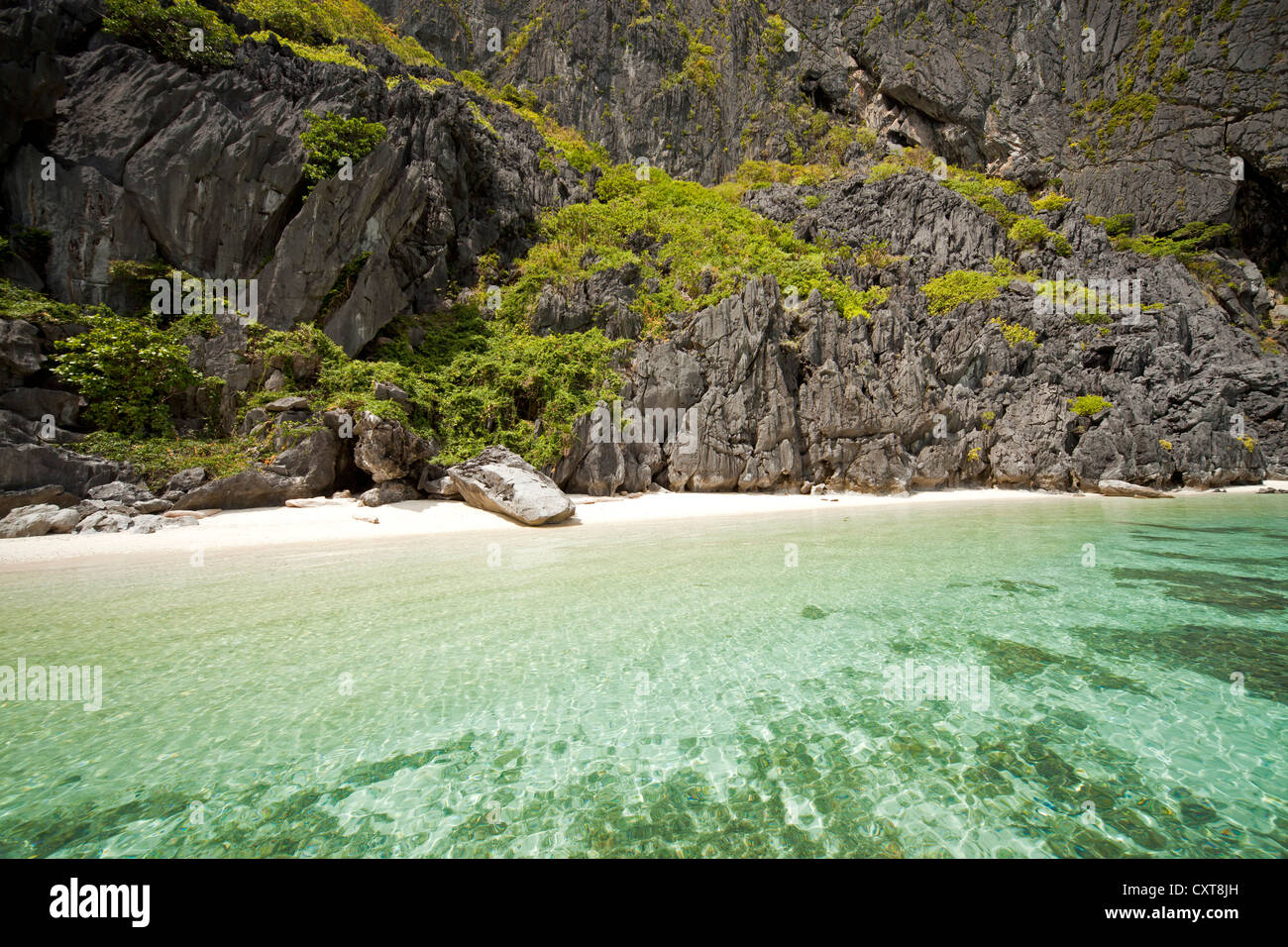 Bay on the steep limestone coast of Tapiutan Island, Bacuit archipelago ...