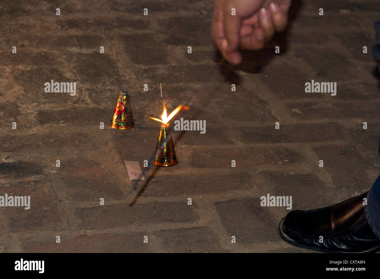 Man lighting a fire cracker during the festival of Diwali. These are ...