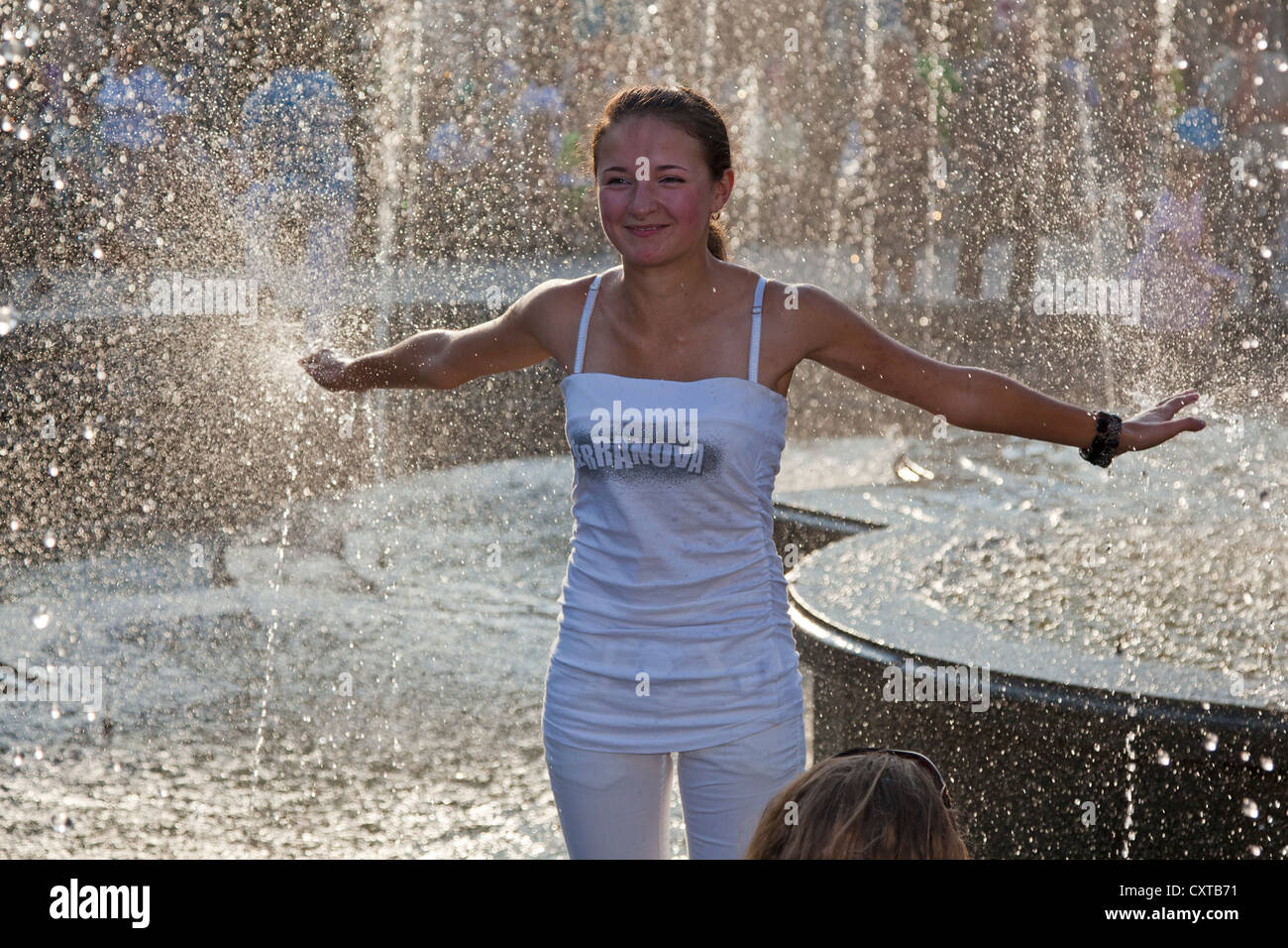 Girl playing in water fountain hi-res stock photography and images - Alamy